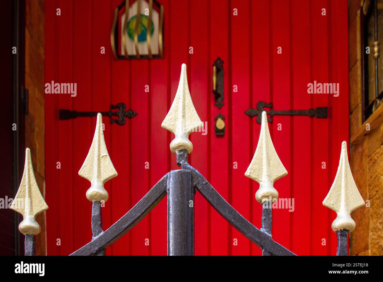 Red Door with Ornamental Metallic Spike Fence in Architectural Setting ...
