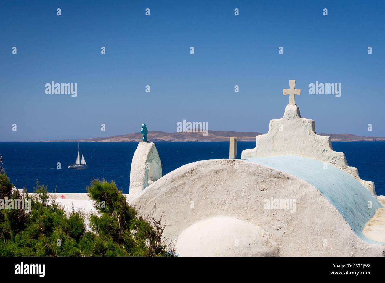 Classic white greek church roof in bright sun on Mykonos with sea in ...