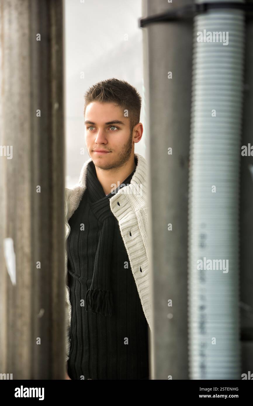 Happy young man outdoor seen between two pillars. Wearing winter clothes Stock Photo - Alamy