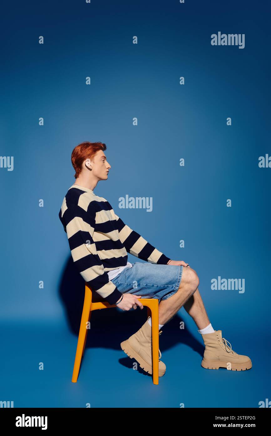 A young man sits thoughtfully in a vibrant chair, expressing deep ...