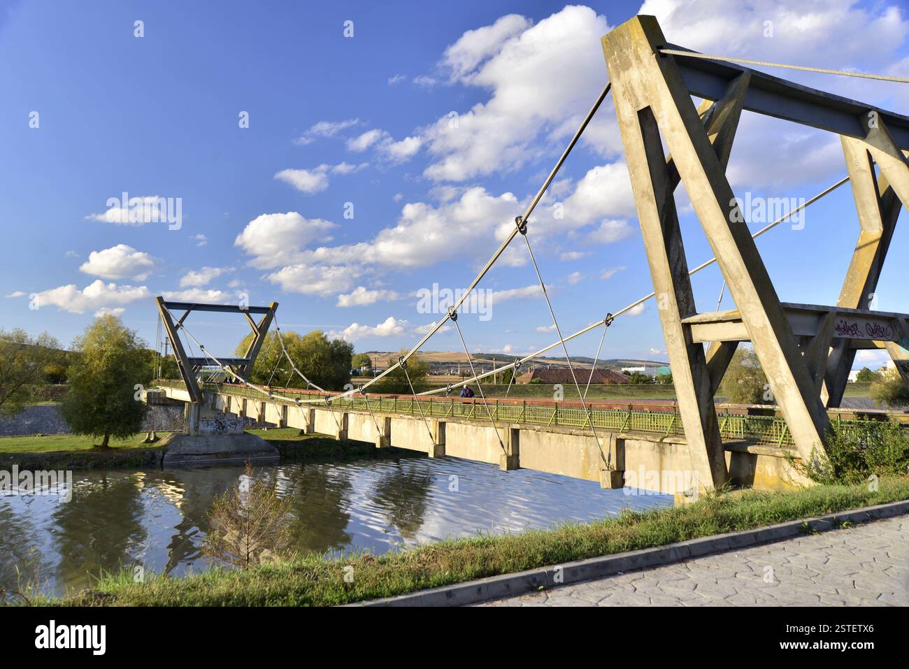 Pedestrian footbridge over the Mures river and cumulus clouds in the ...