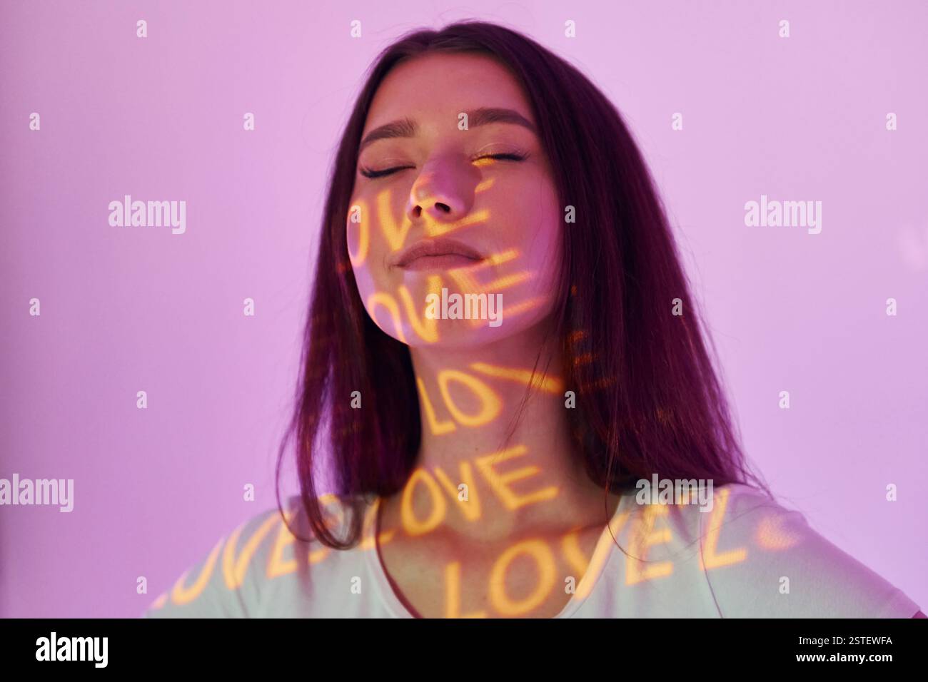 Conception of love. Beautiful young woman is in projector neon lights ...