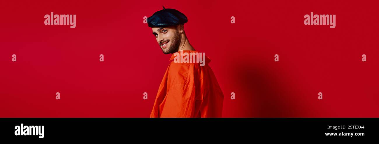 Romantic young man wearing beret poses confidently in a vibrant red ...