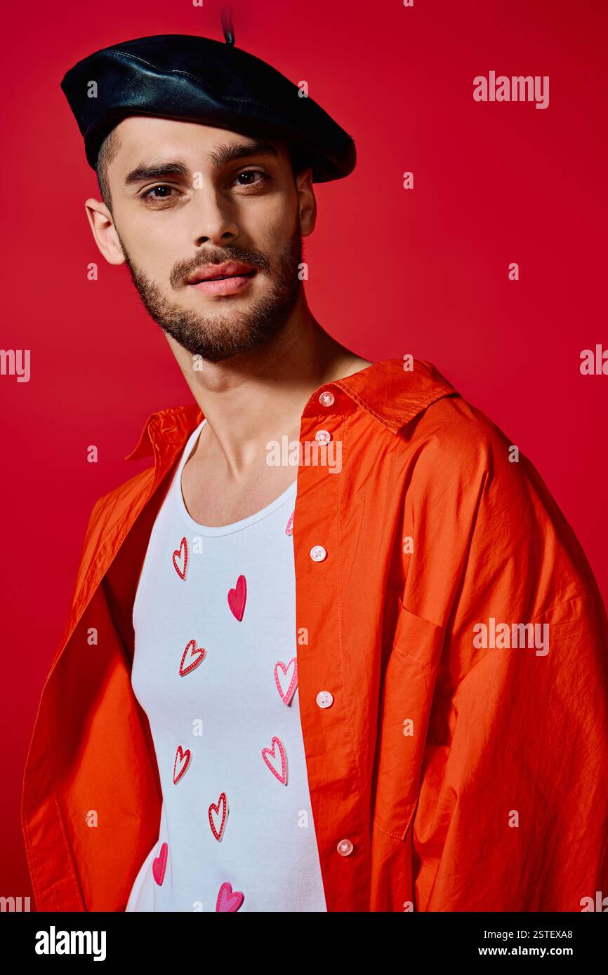 A young man displays his unique style in a studio with a red backdrop ...