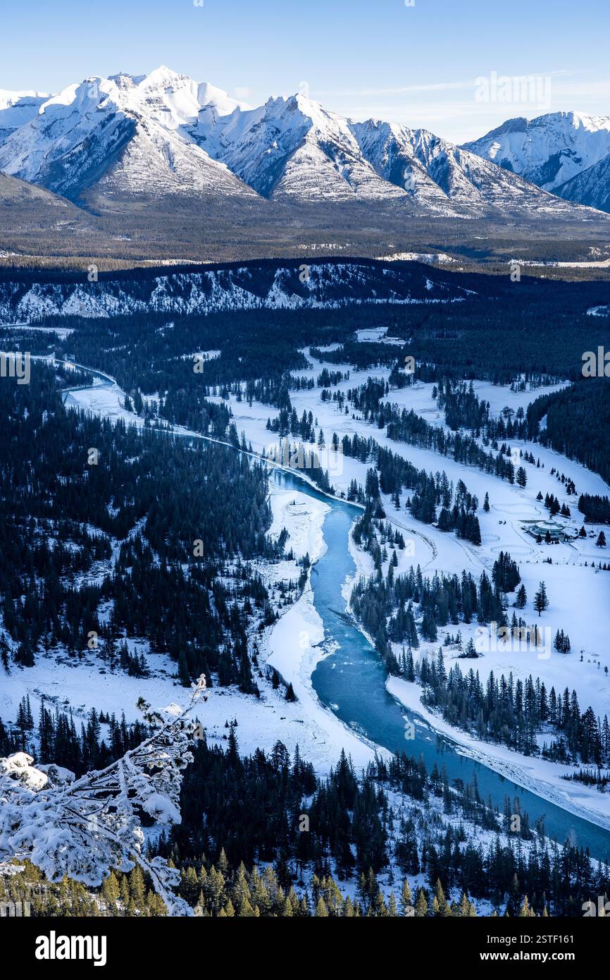 Looking down view winter river flowing through snow covered mountains ...