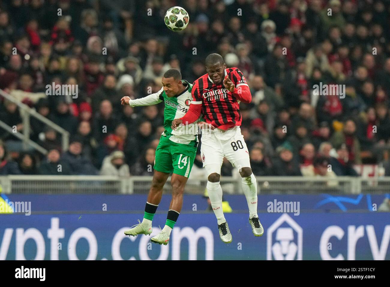 AC Milan's Yunus Musah, right, jumps for a header with Feyenoord's Igor Paixao during Champions ...