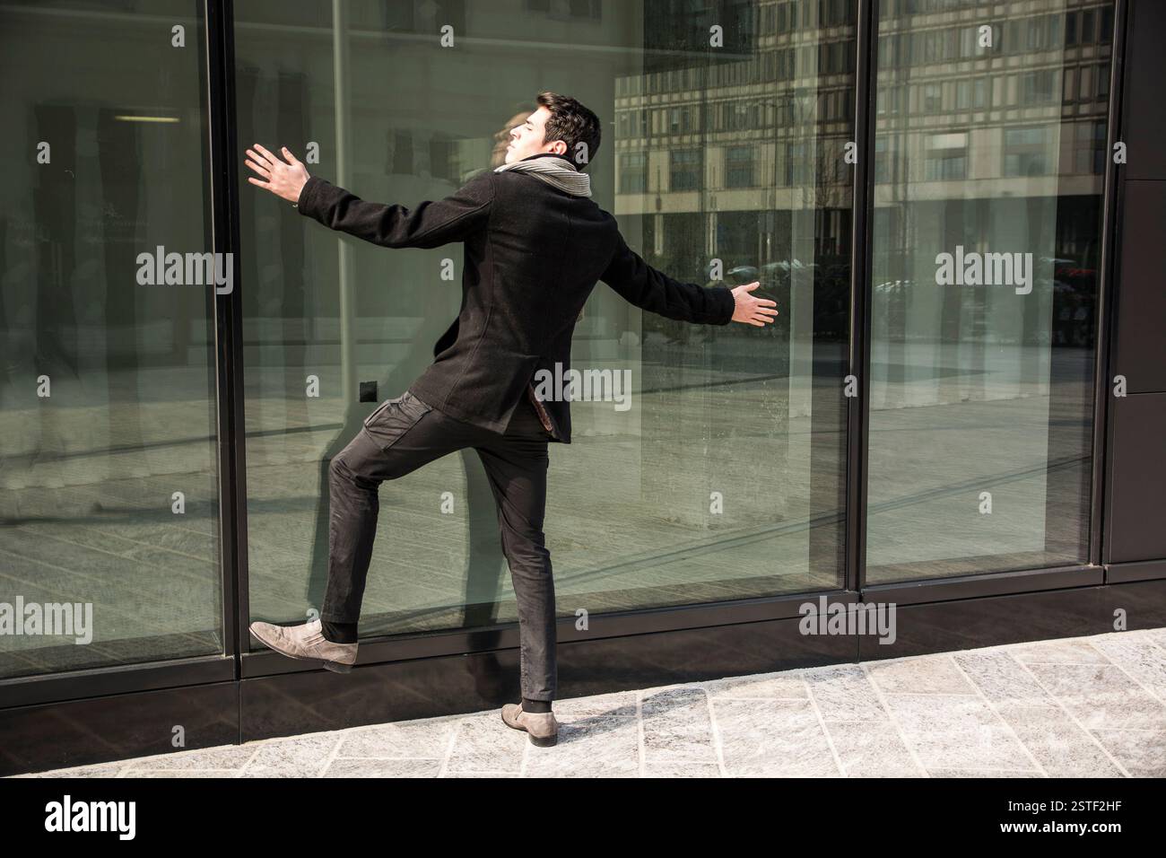Man Leaning Against Window of Office Building Stock Photo - Alamy