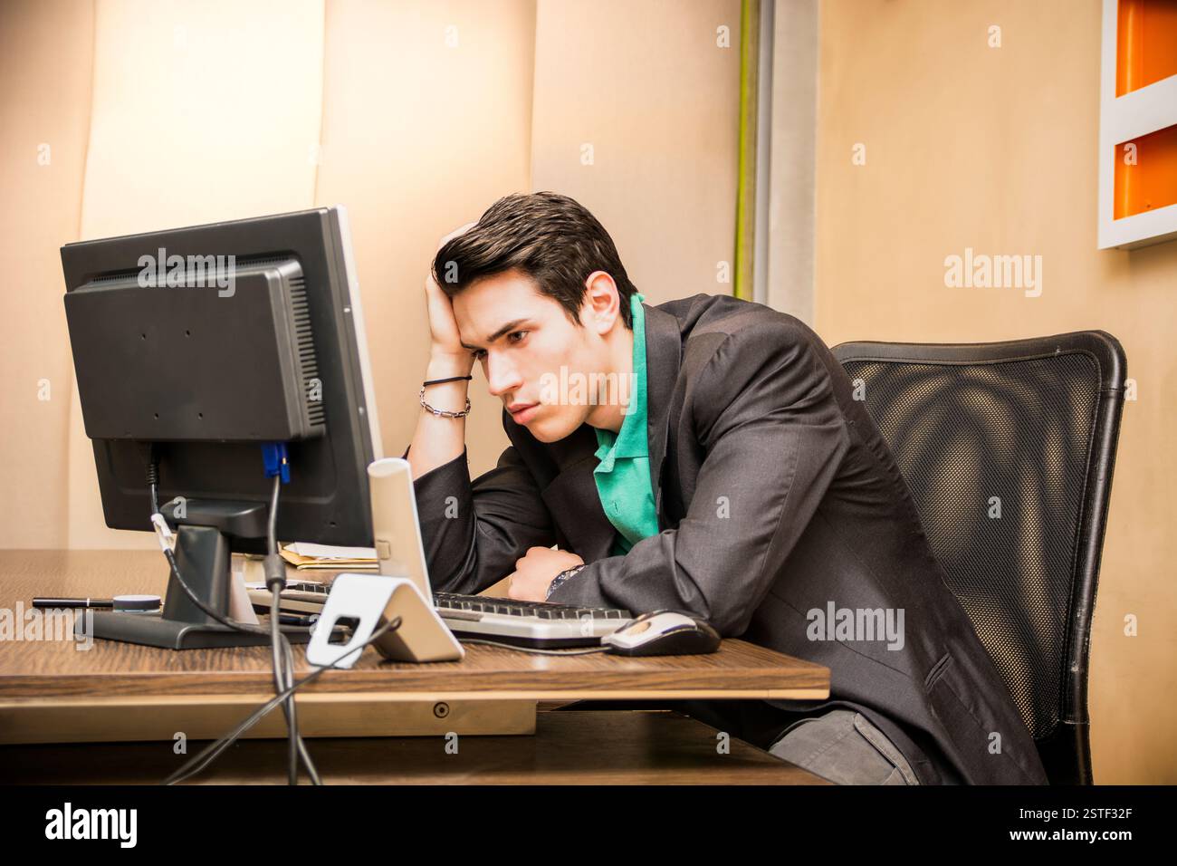 Worried young male staring at computer screen in his office hi-res ...