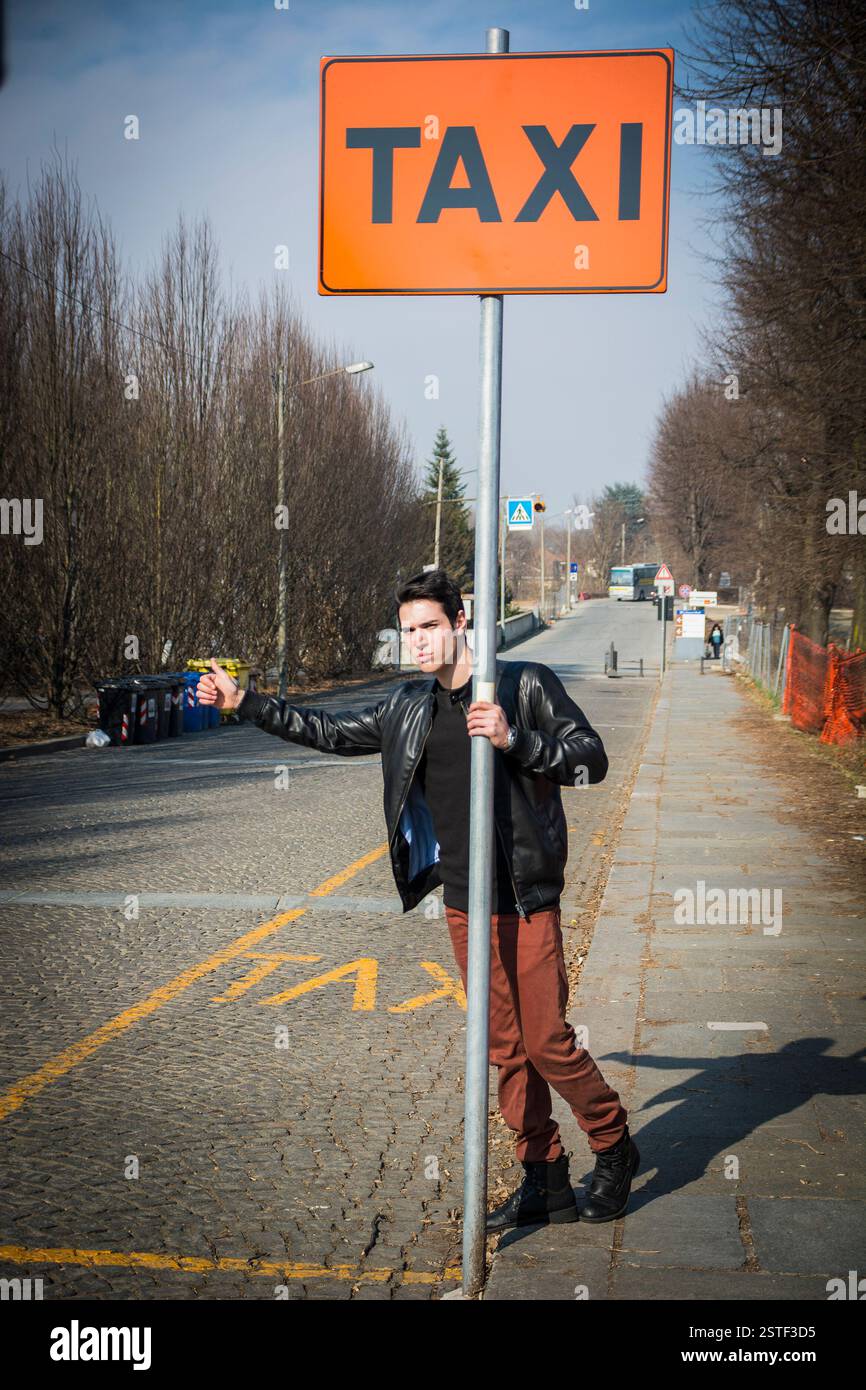 Young man hailing a taxi Stock Photo - Alamy