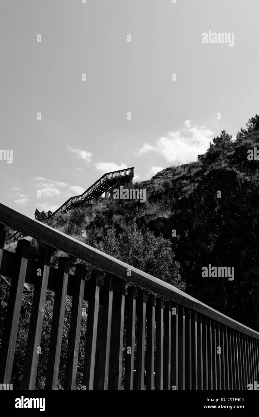 Black and white view of a wooden walkway and staircase along the ...