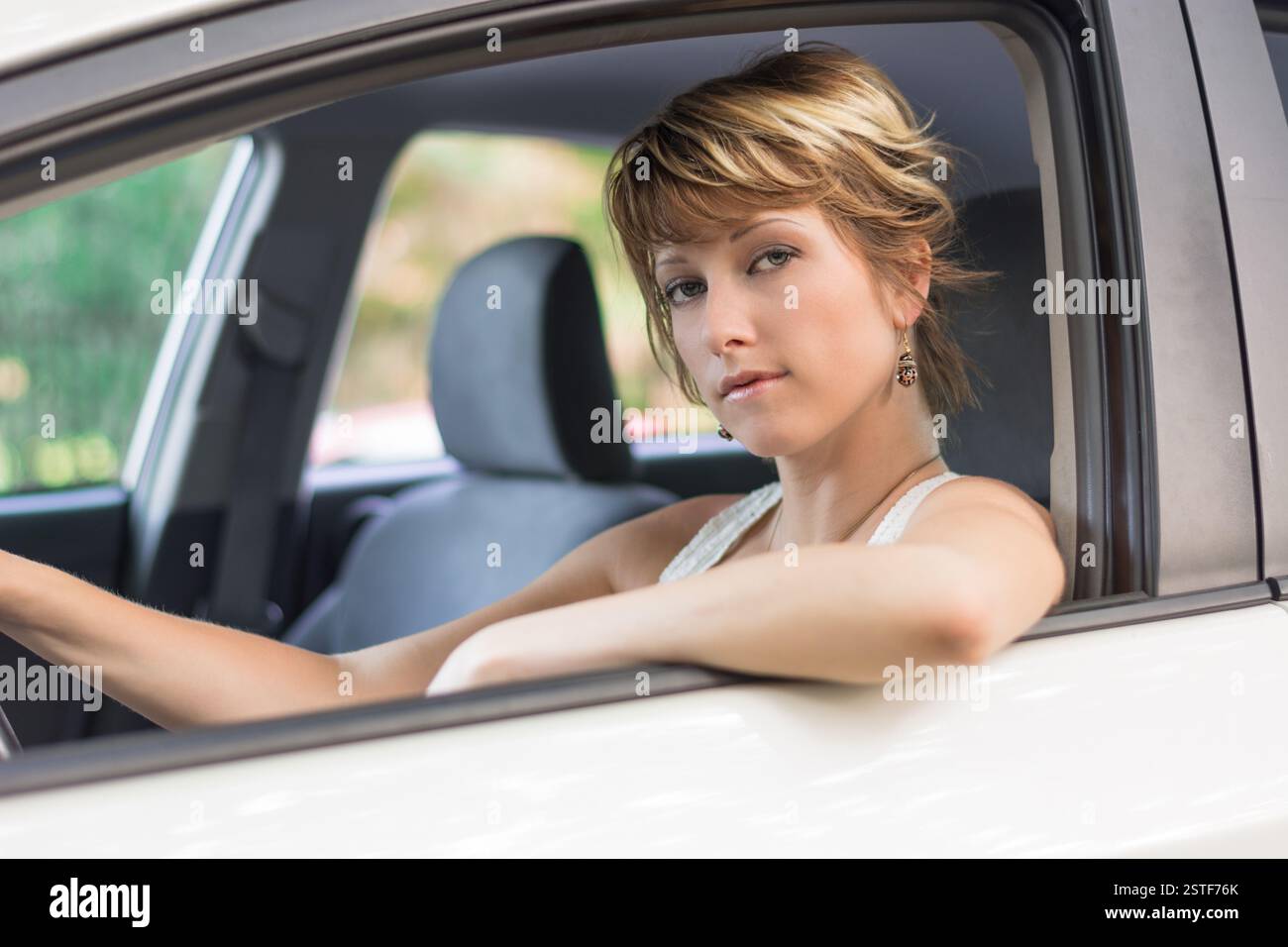Serious pretty blonde young woman driving car Stock Photo - Alamy