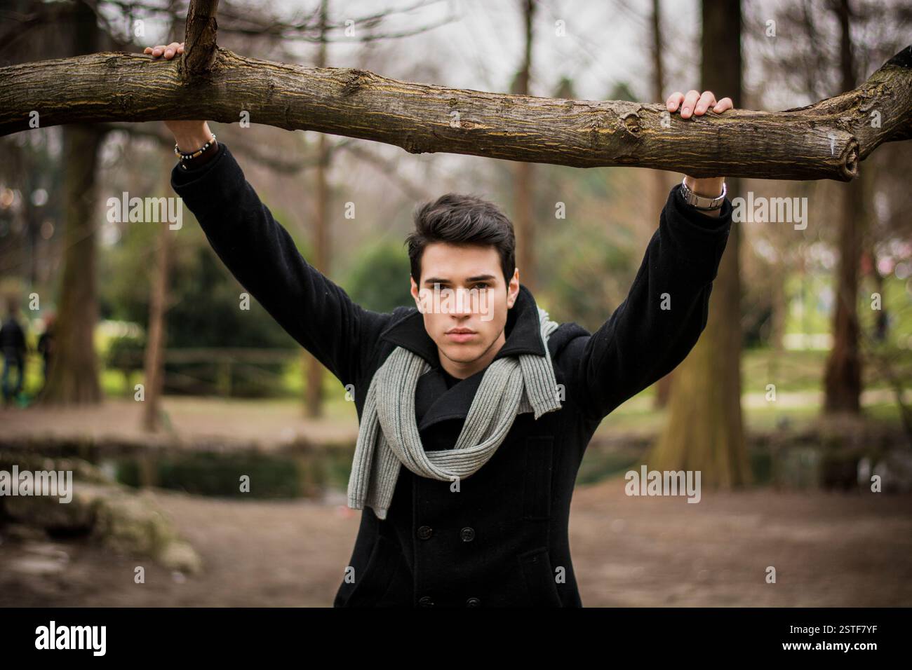 Stylish Man Leaning on Tree Branch Looking Afar Stock Photo - Alamy