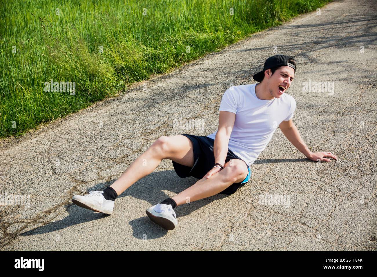 Handsome young man injured while running and jogging on road in the ...