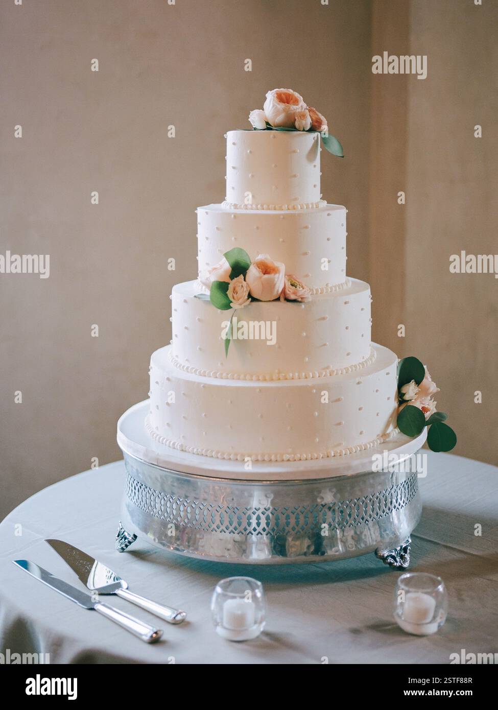 A stunning four-tier wedding cake with floral accents displayed ...