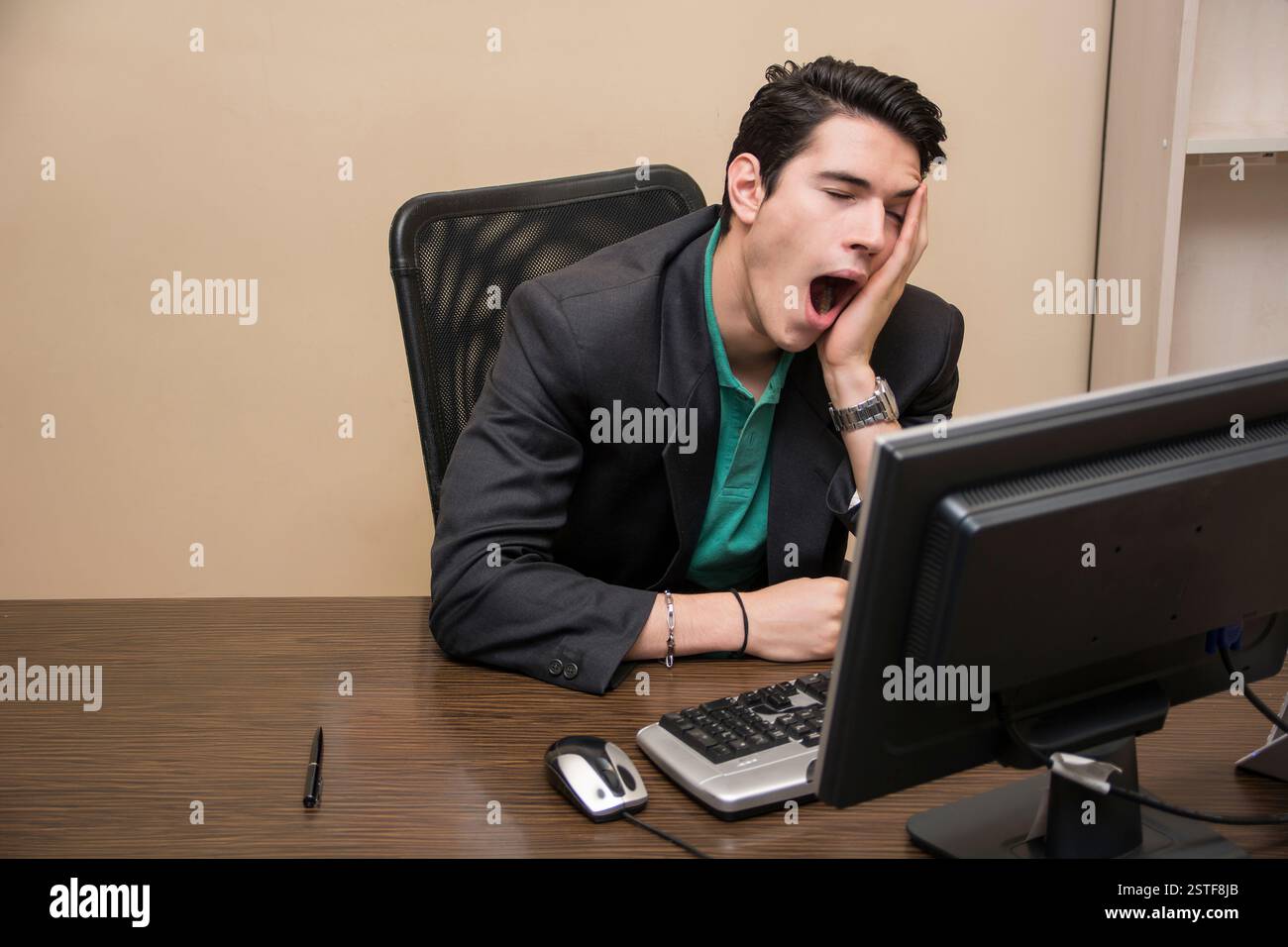 Tired bored young businessman sitting in office yawning Stock Photo - Alamy