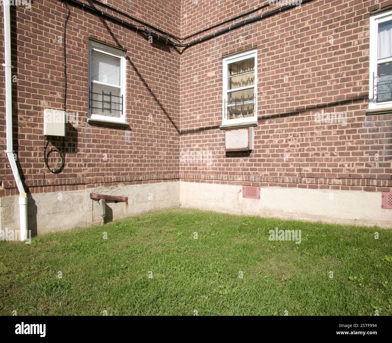 Urban Brick Building Exterior with Small Grass Yard. The urban scene is ...