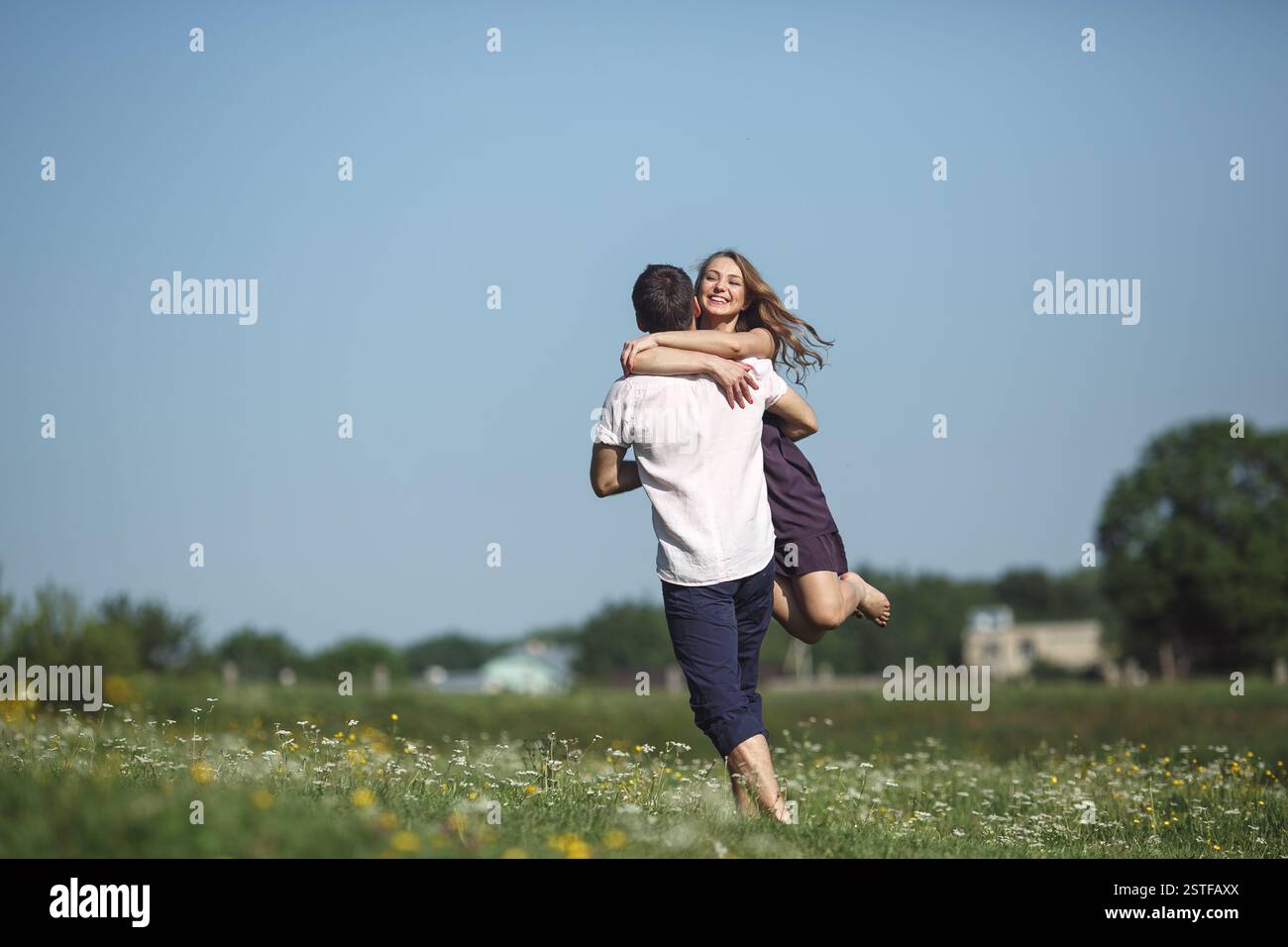 Couple running in field and have fun Stock Photo - Alamy