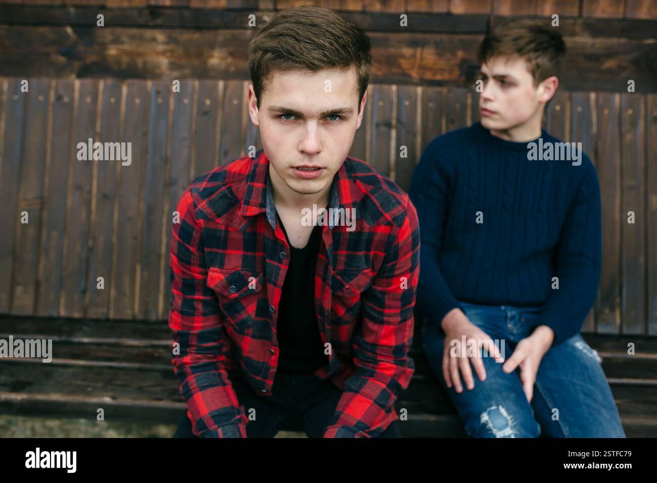Two men sitting on a wooden bench in nature hi-res stock photography ...