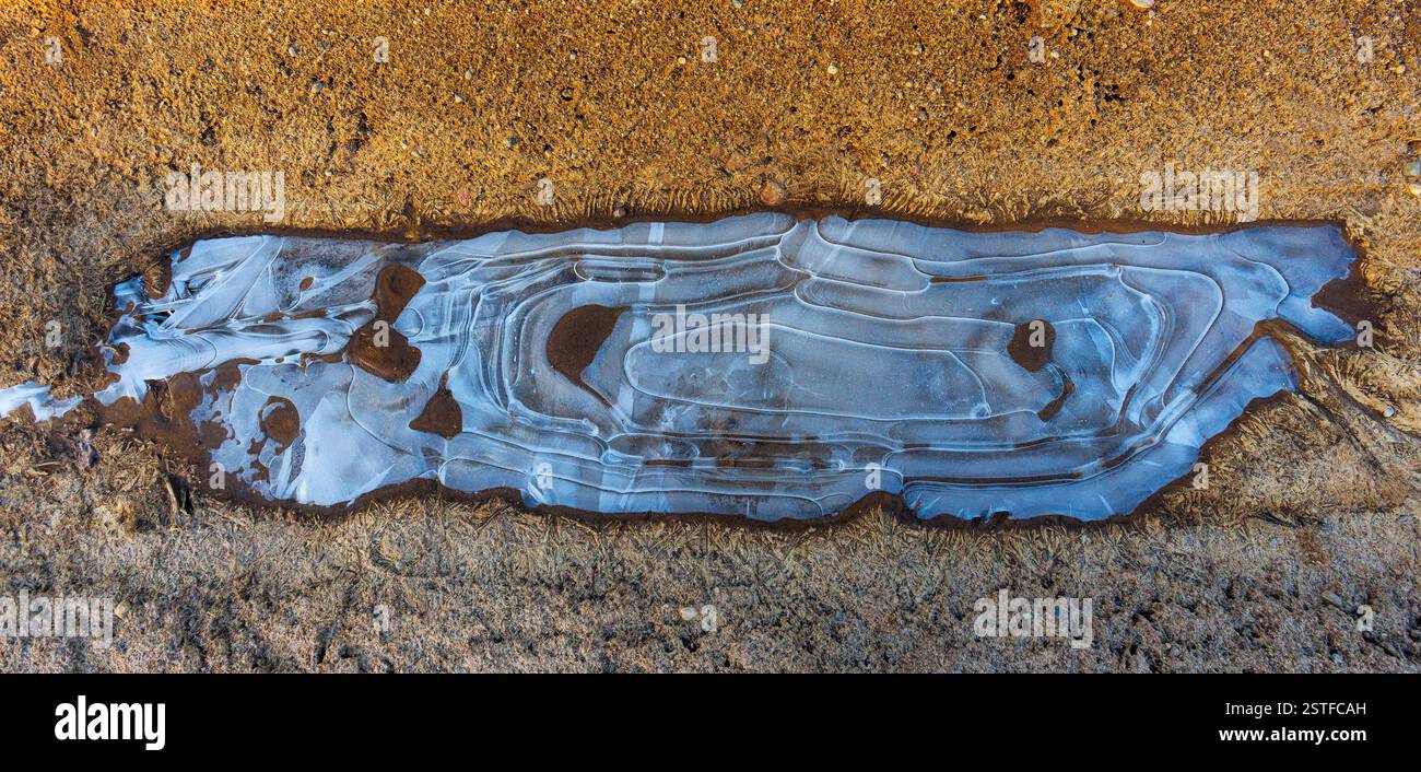 Frozen water on the ground, pattern of ice Stock Photo - Alamy