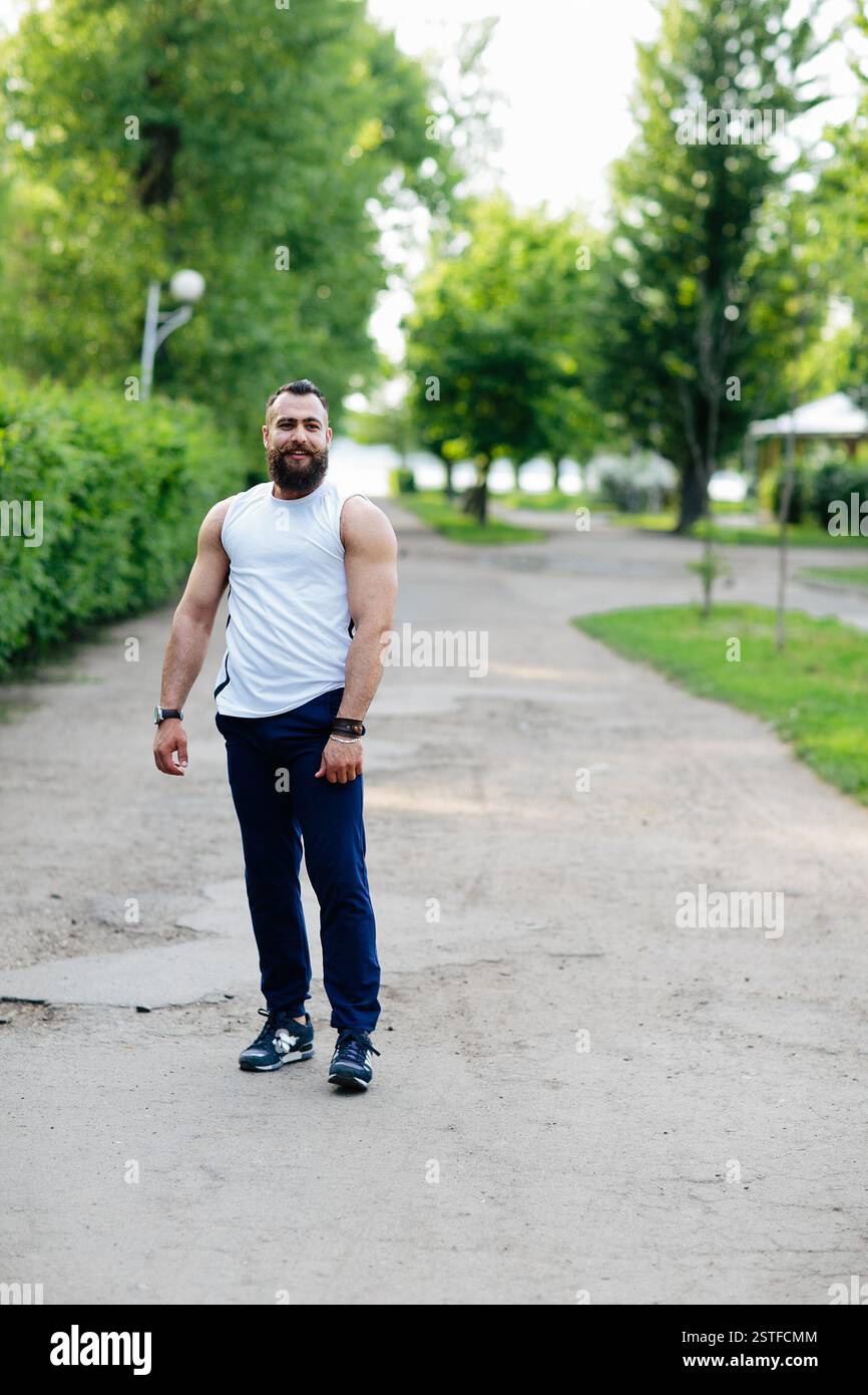 Bearded man running cross in the park at green fence hi-res stock ...