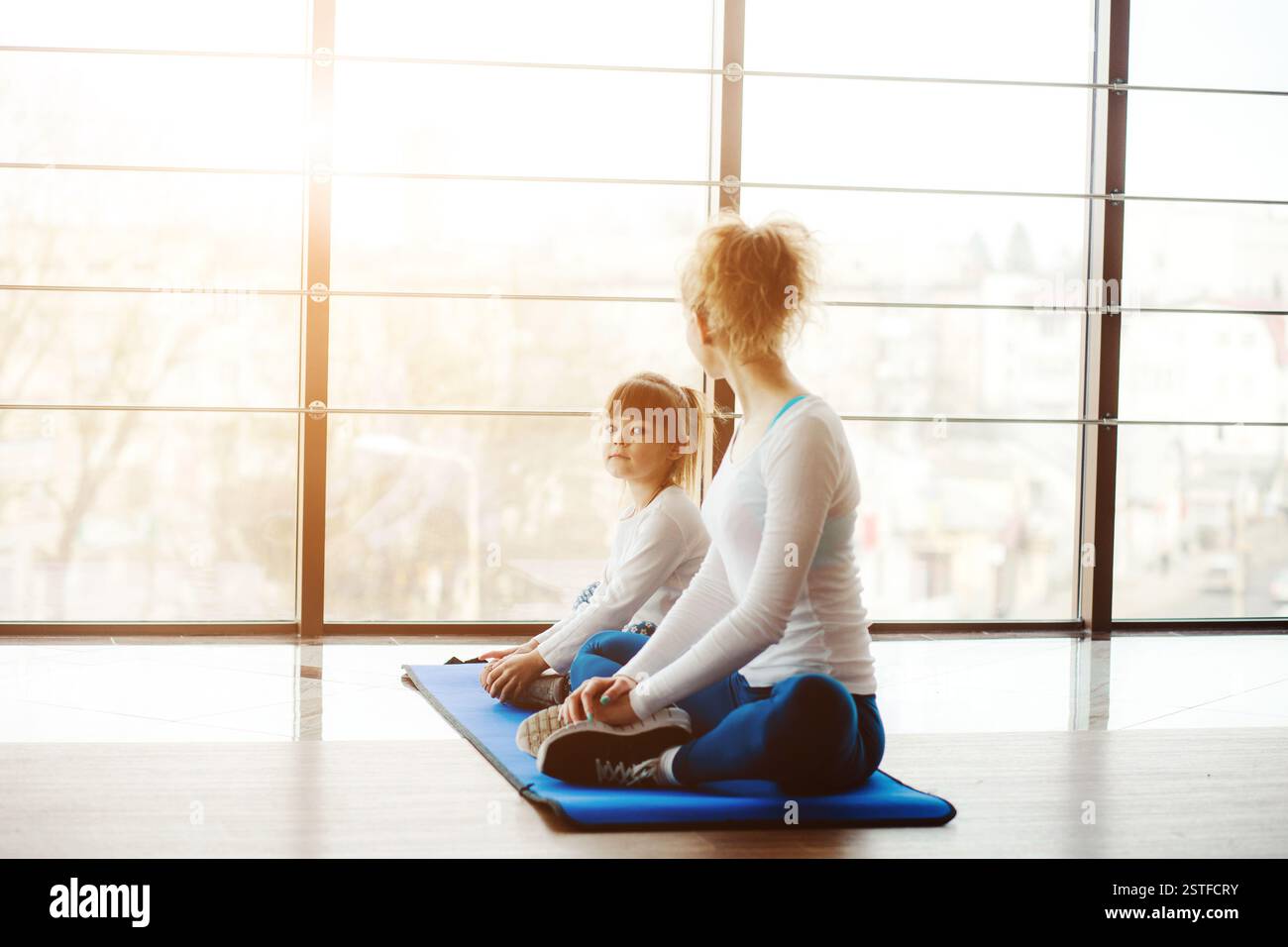 Two girls of different ages makeing yoga Stock Photo - Alamy