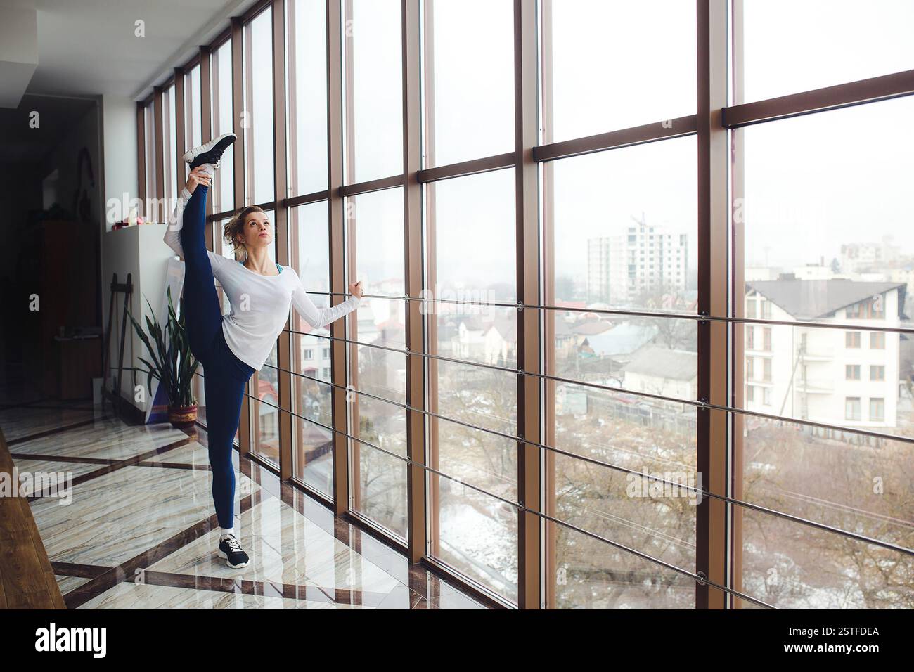 Mother makeing super high leg stretch in the gym Stock Photo - Alamy