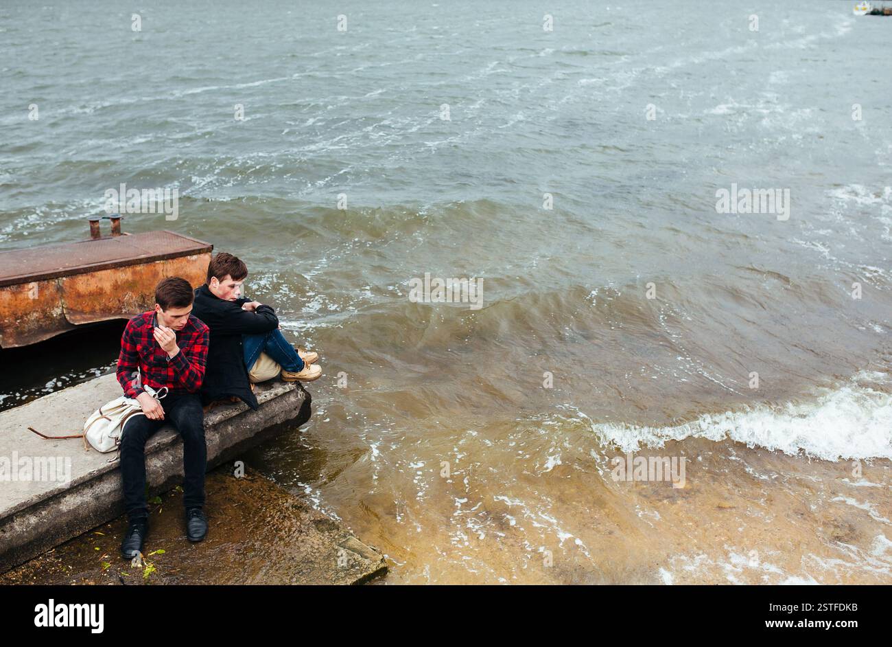 Two friends relaxing on the pier Stock Photo - Alamy