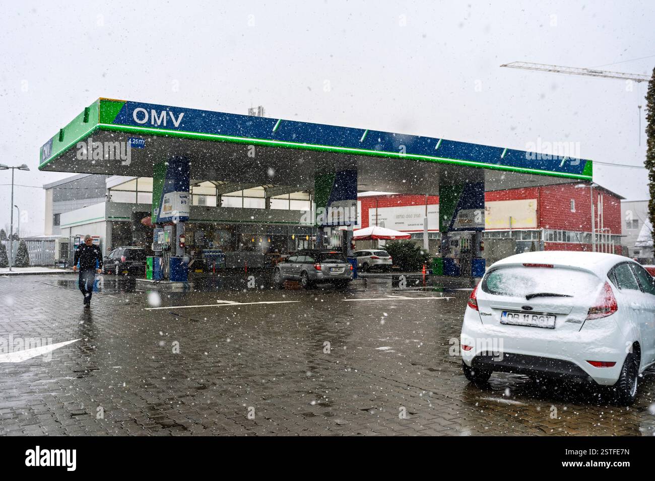 Exterior of an OMV gas station. Gasoline pumps and cars refueling in a ...