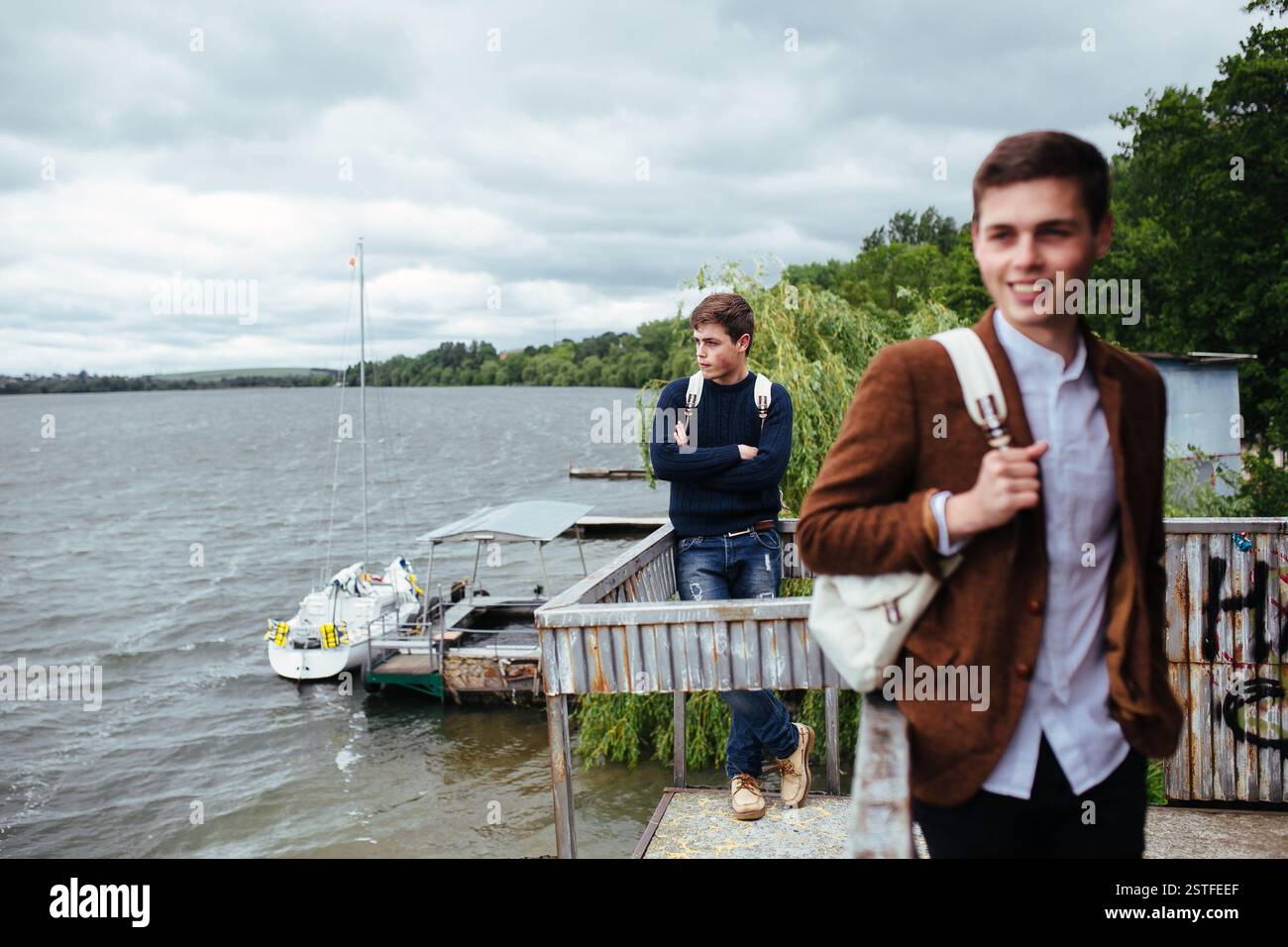 Two young guys standing on a pier Stock Photo - Alamy