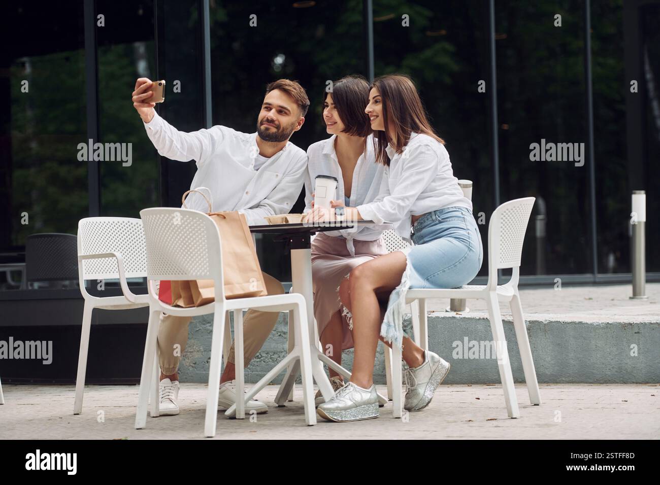 Sitting on the chairs. Three friends having great weekend outdoors ...