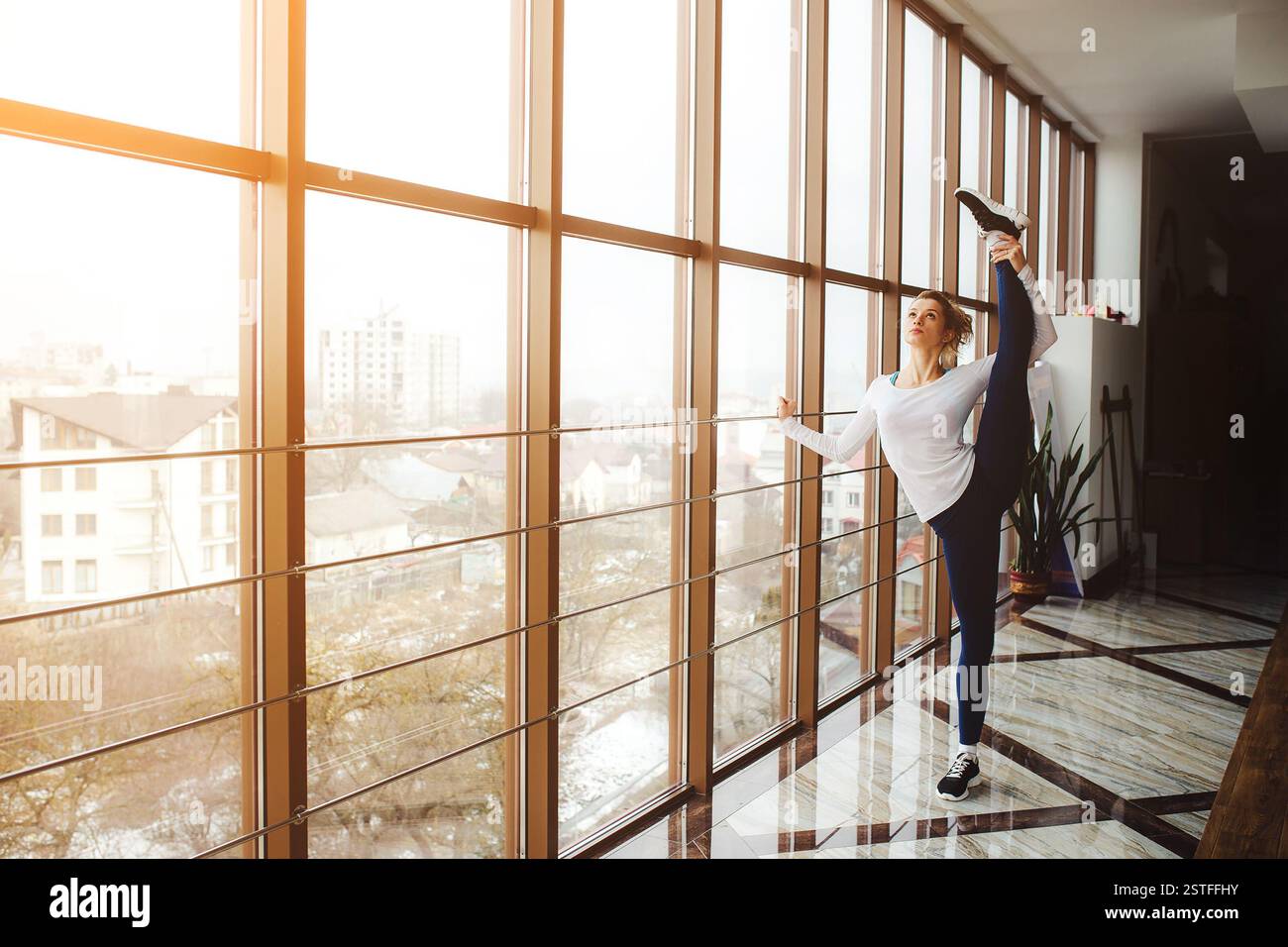 Mother makeing super high leg stretch in the gym Stock Photo - Alamy
