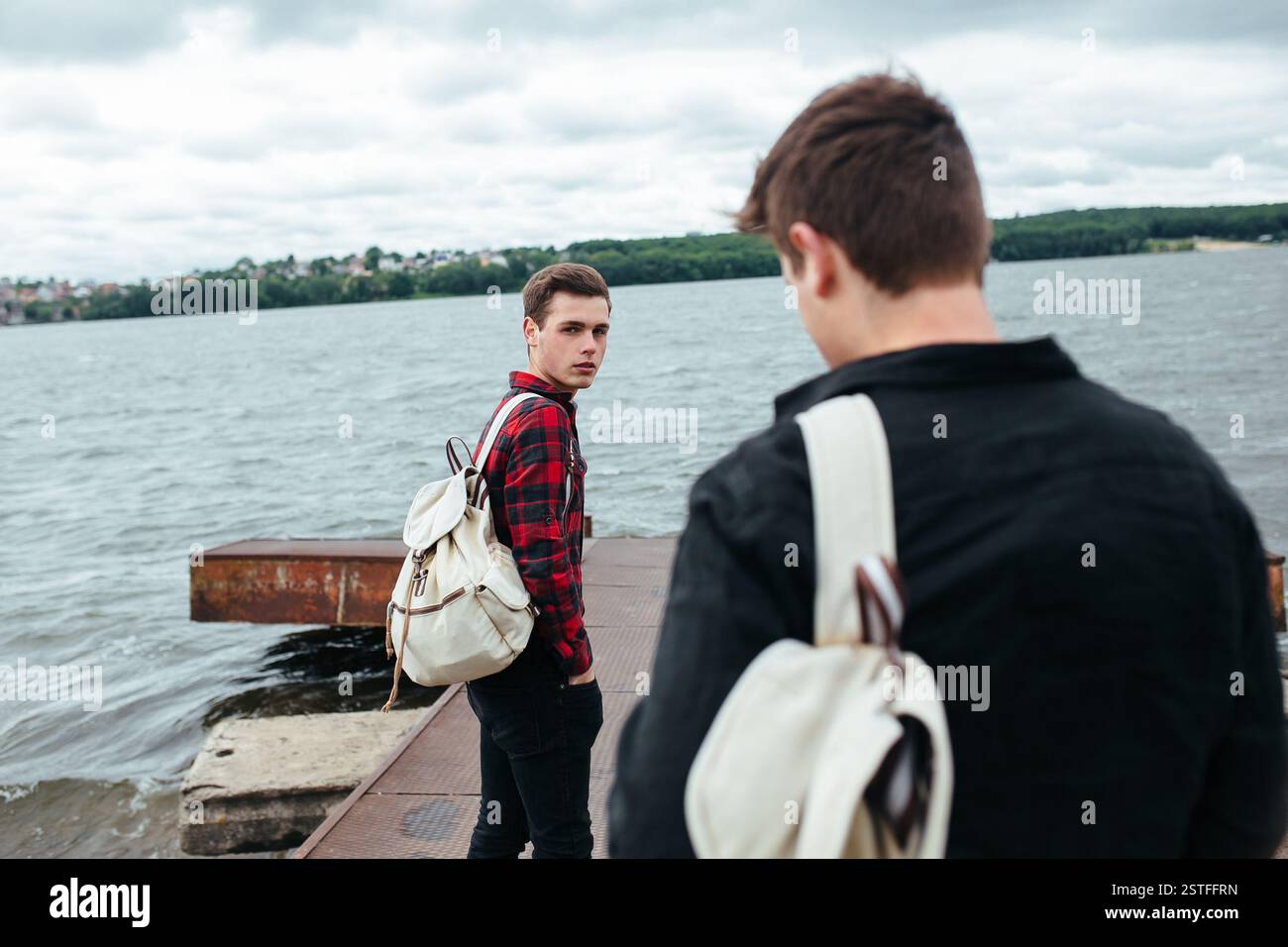 Two young guys standing on a pier Stock Photo - Alamy
