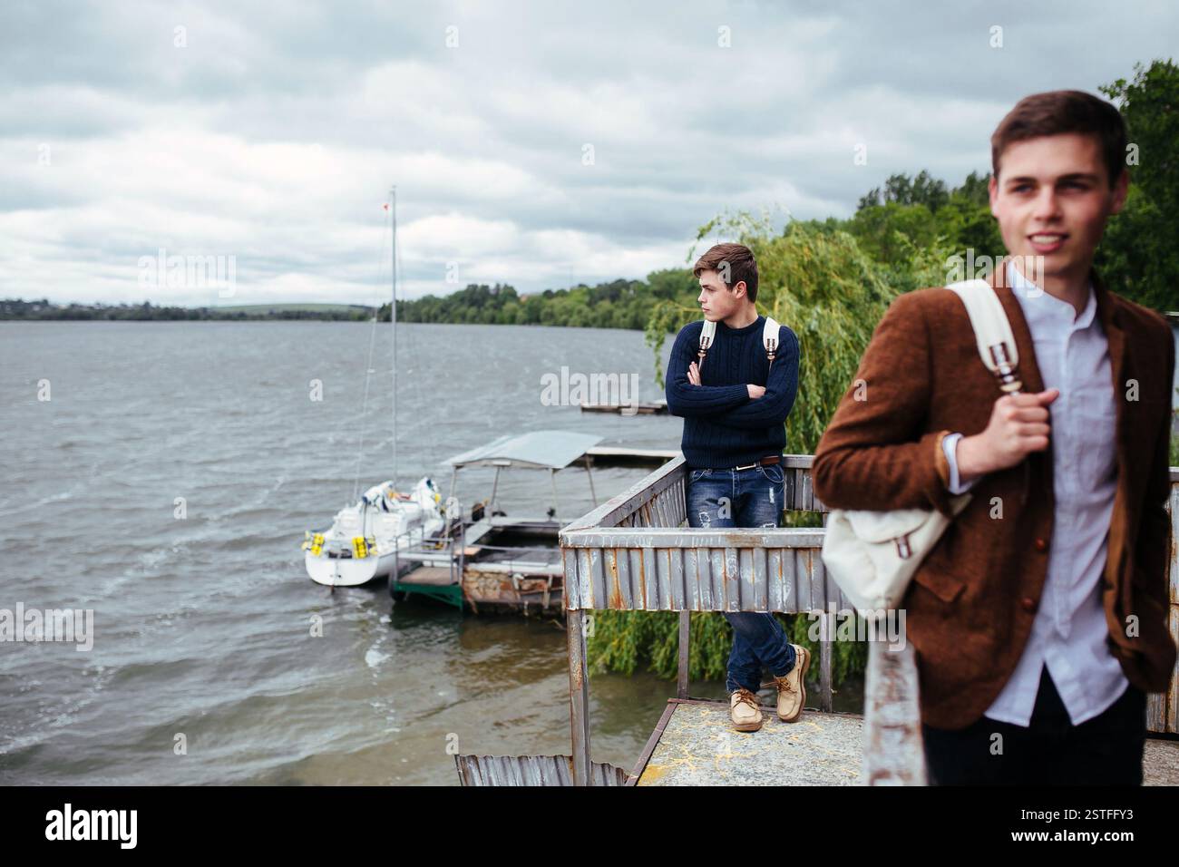 Two young guys standing on a pier Stock Photo - Alamy