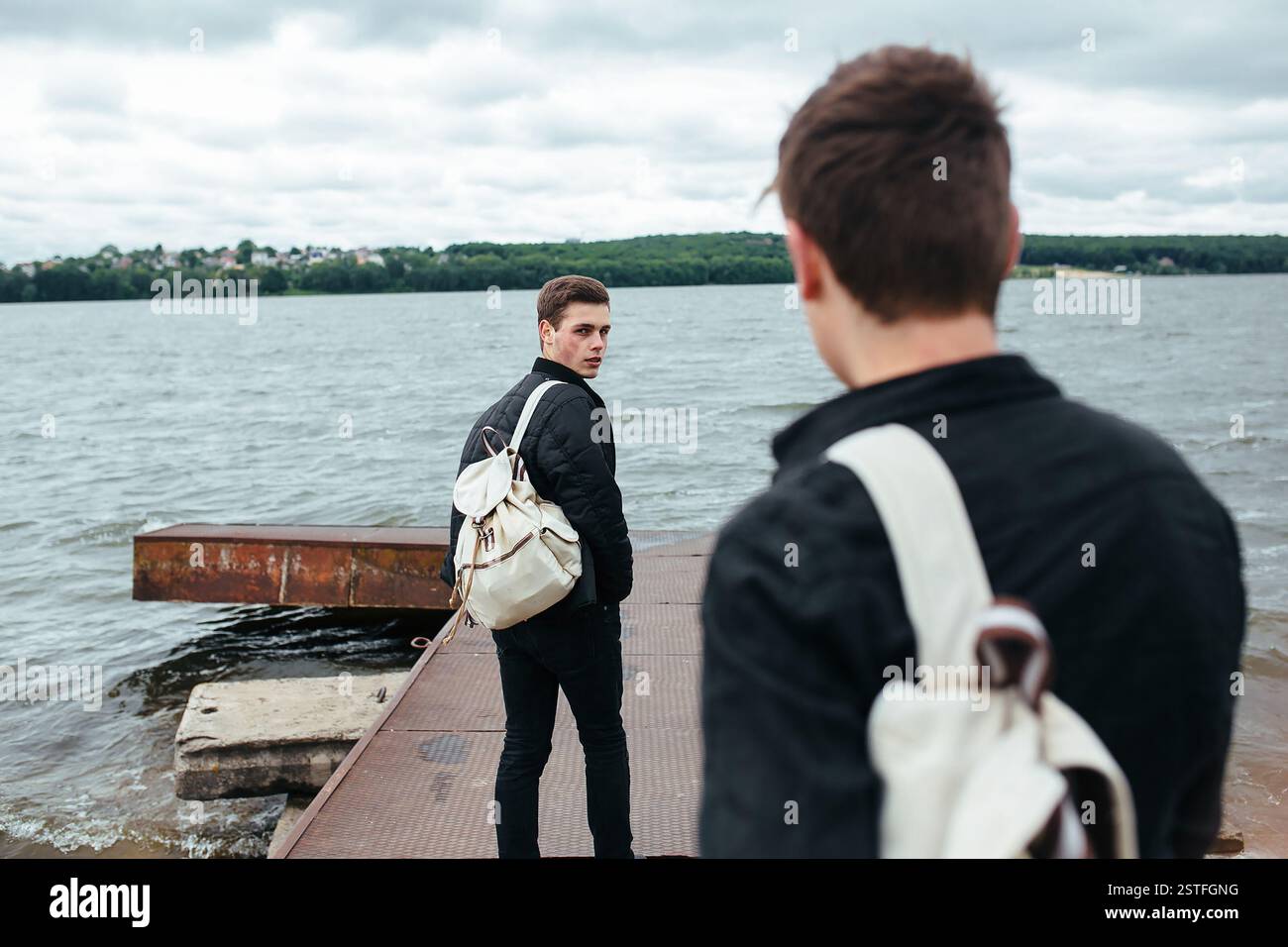 Two young guys standing on a pier Stock Photo - Alamy