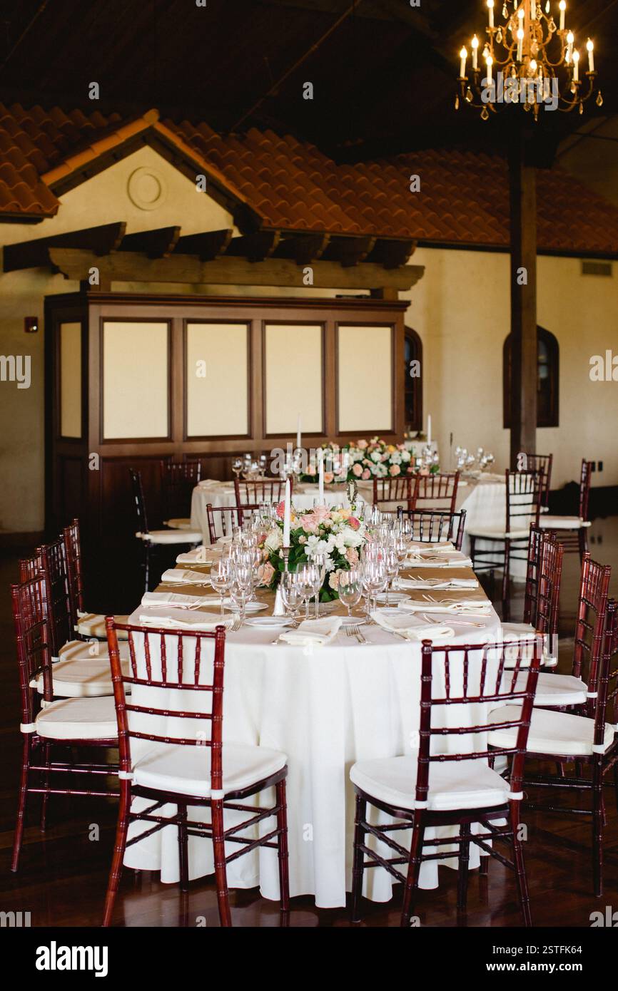 A sophisticated dining arrangement featuring tables set with flowers ...