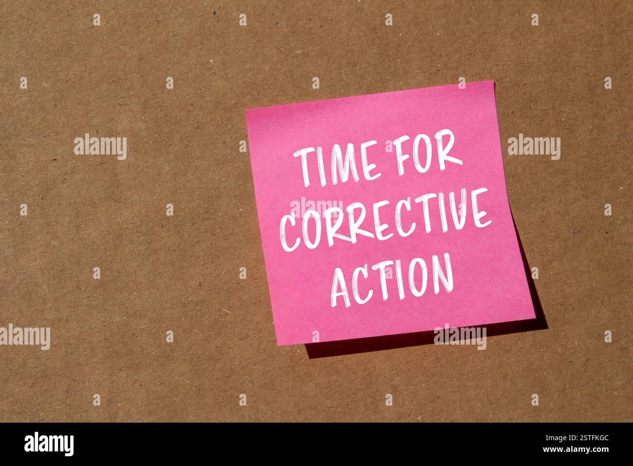 Time for corrective action message written on pink paper on brown ...