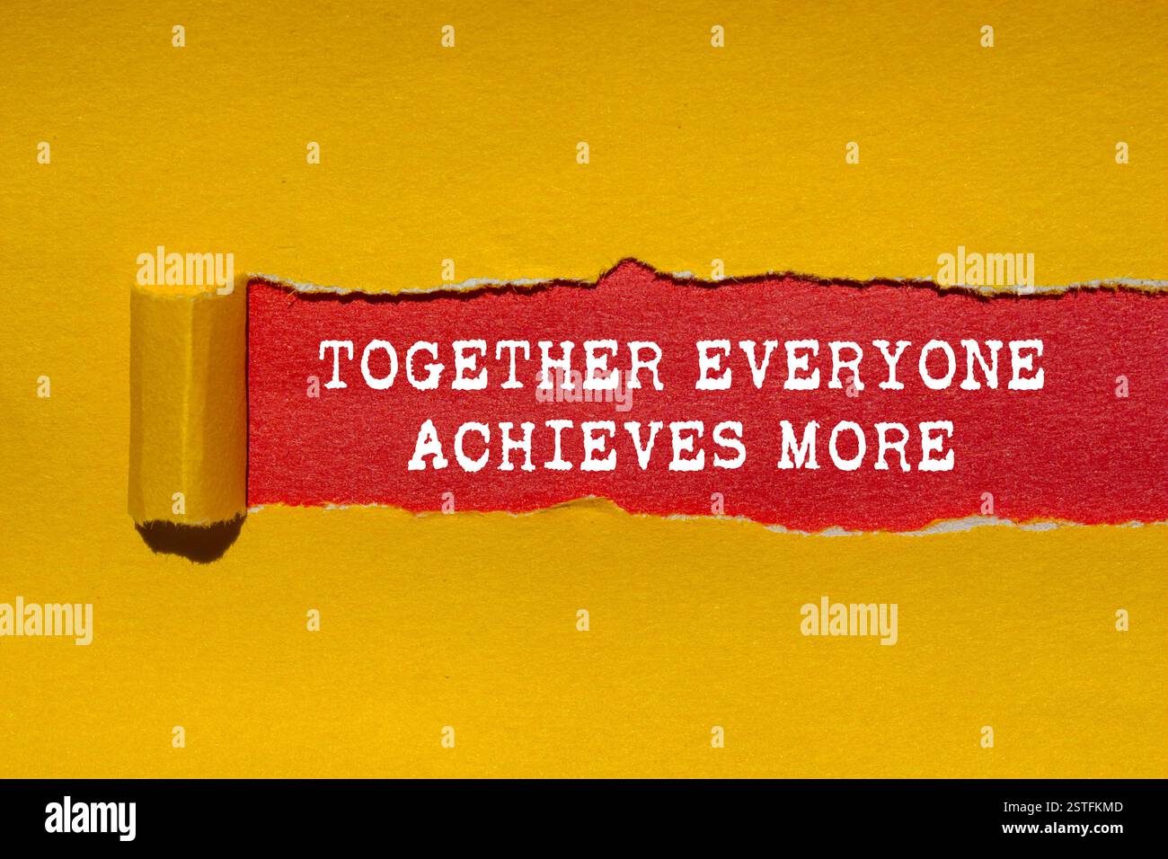 Together everyone achieves more message written on ripped torn yellow ...