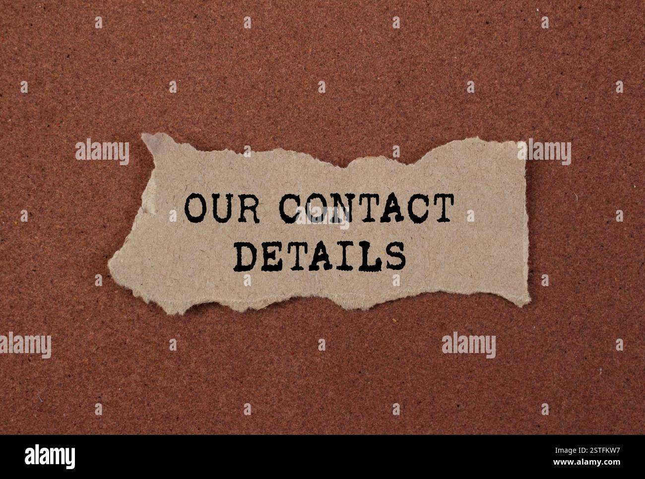 Our contact details message written on ripped torn paper piece on brown background. Conceptual ...