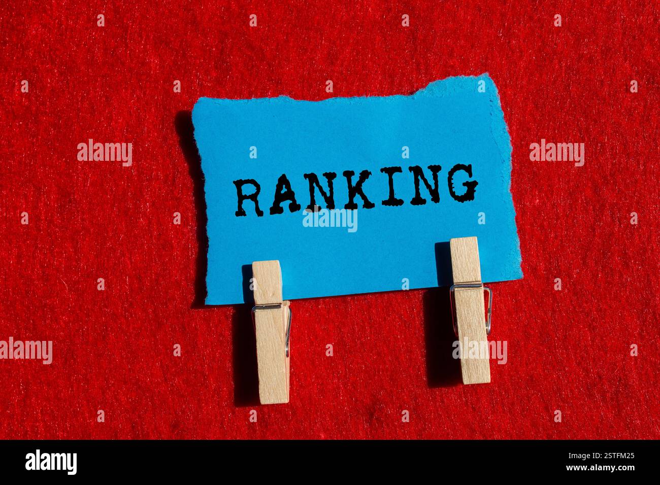Ranking message written on ripped torn blue paper piece on blue background. Conceptual ranking ...