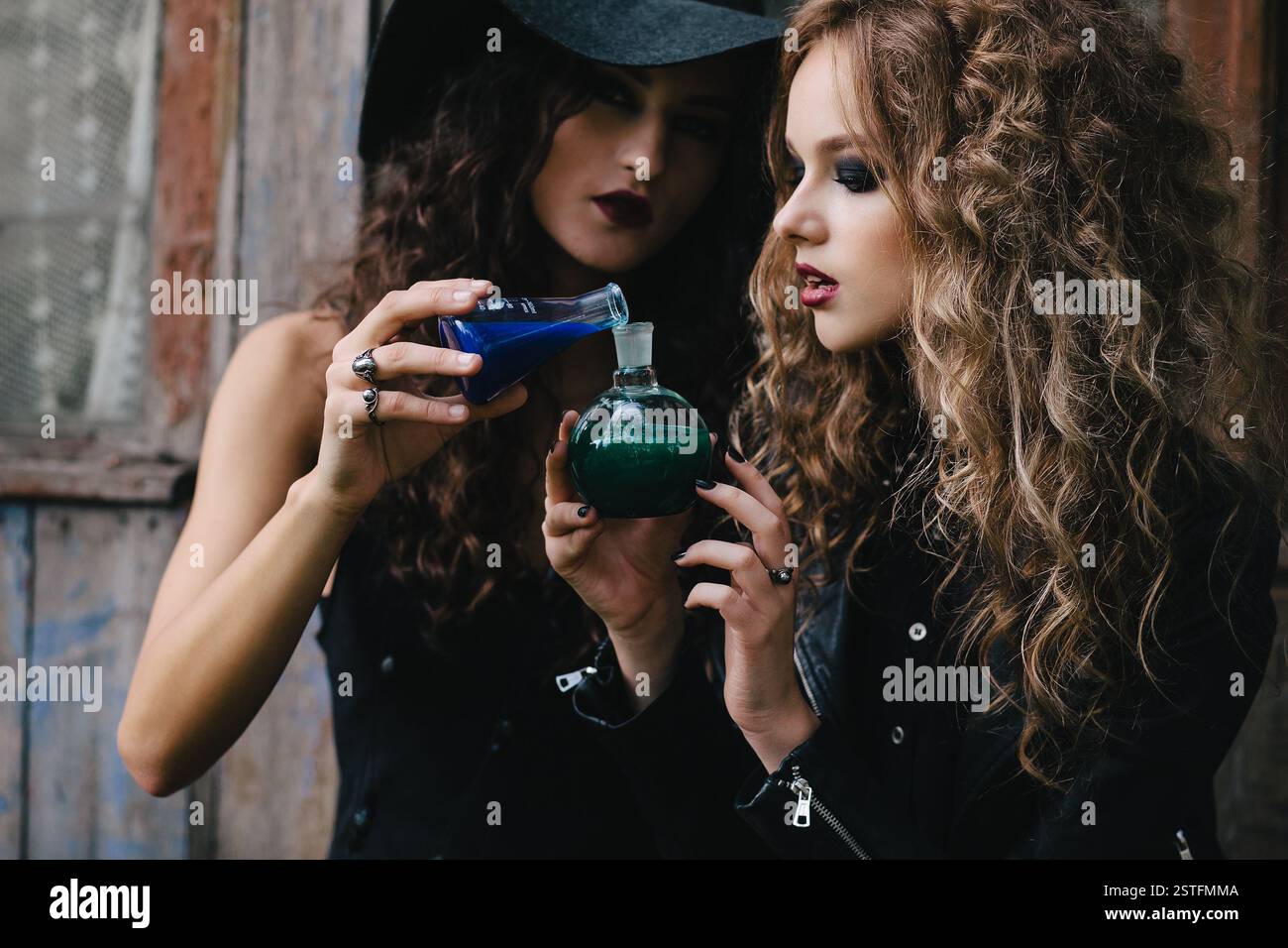 Two vintage witches perform magic ritual, with elixir in hand on the ...