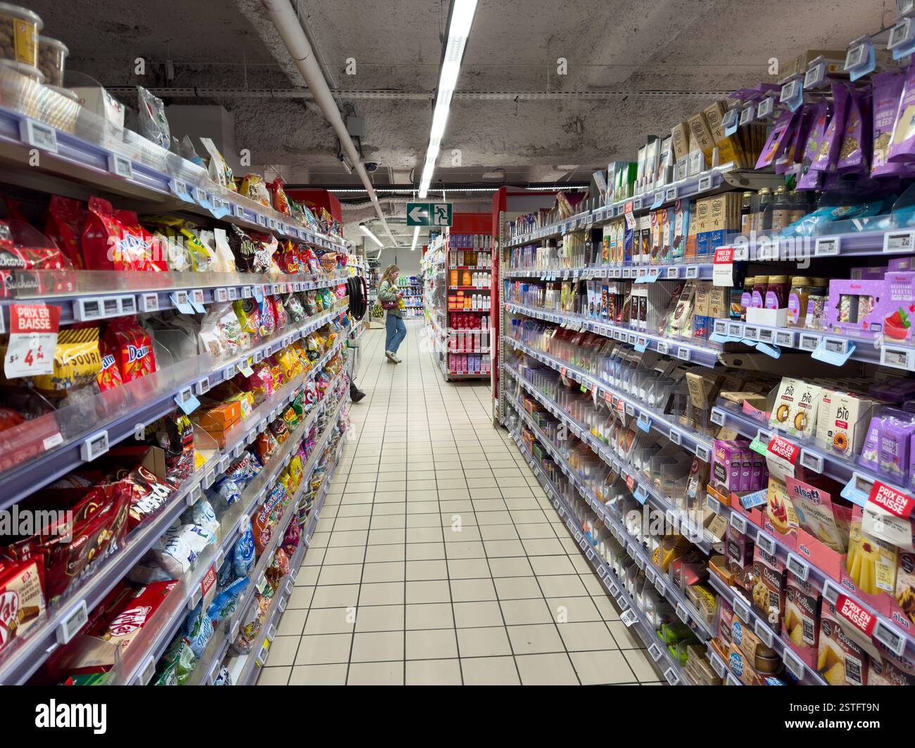 Shopping in a bustling aisle filled with snacks at a vibrant grocery ...