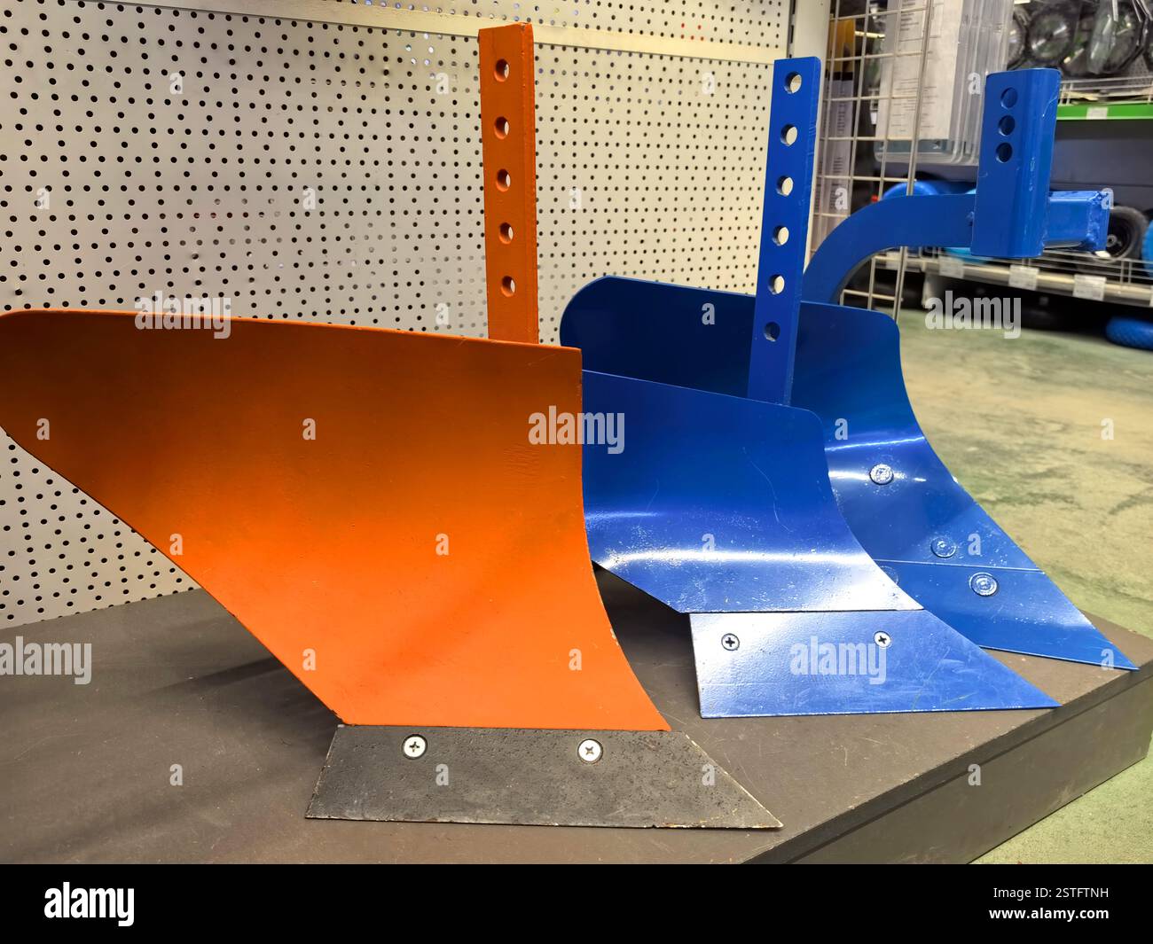 Displayed are two vibrant snow plow blades in orange and blue ...
