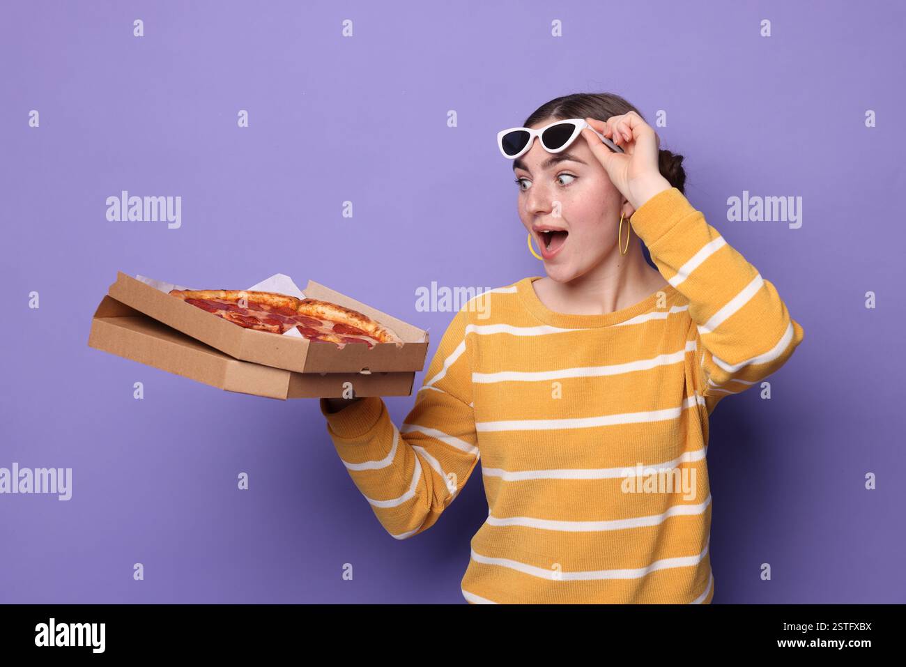 Surprised woman with delicious pizza on violet background Stock Photo ...