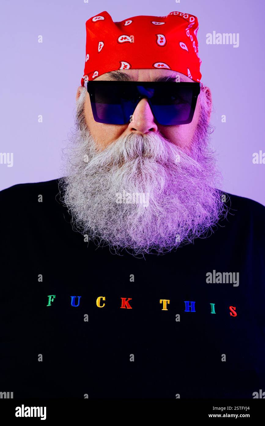 Senior old man with gray beard with biker outfit portrait in studio ...