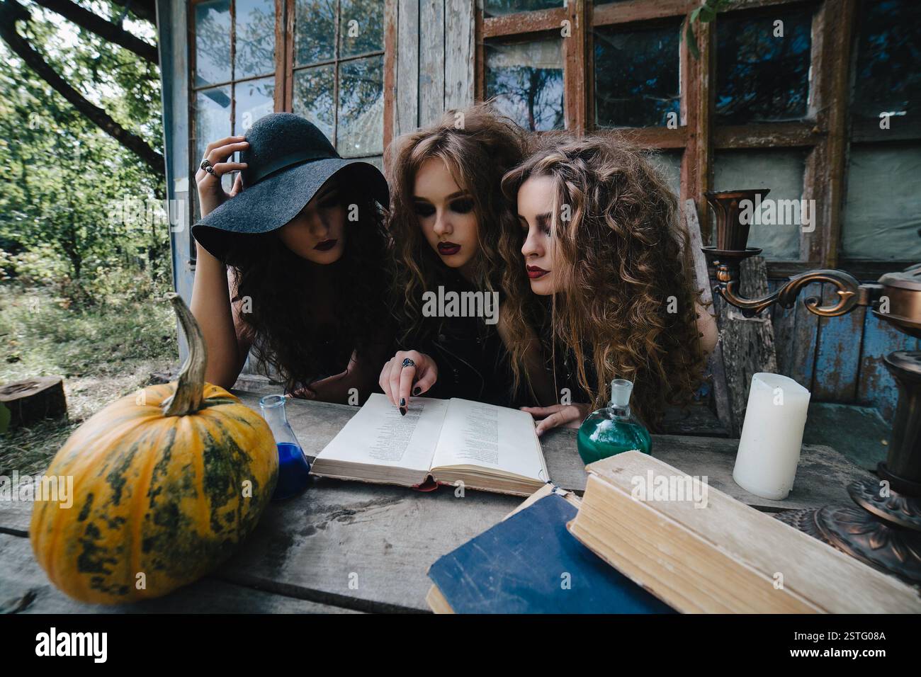 Three vintage witches perform magic ritual Stock Photo - Alamy