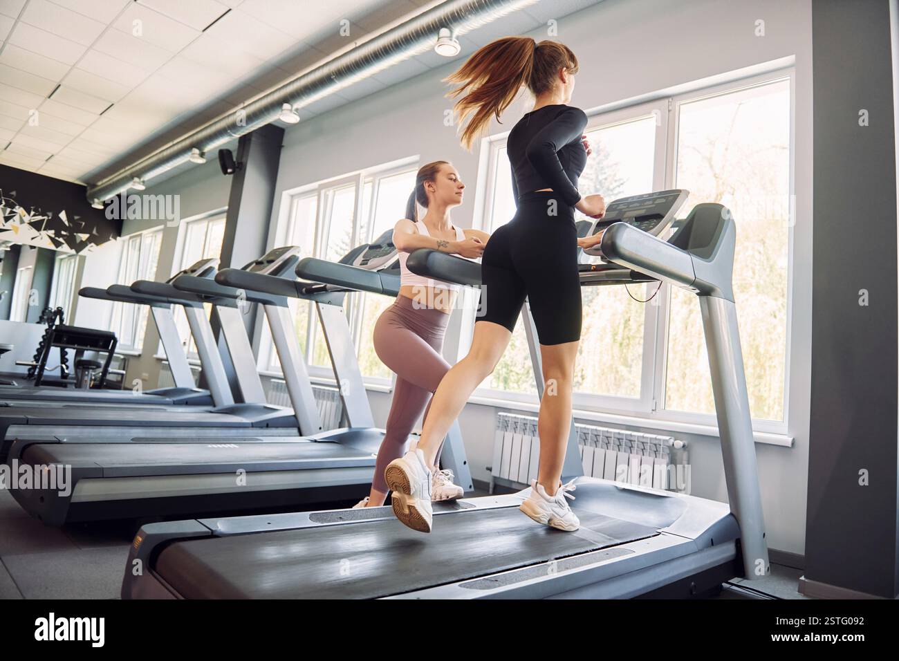 Using racetrack. Two women in sportive clothes have fitness day in the ...