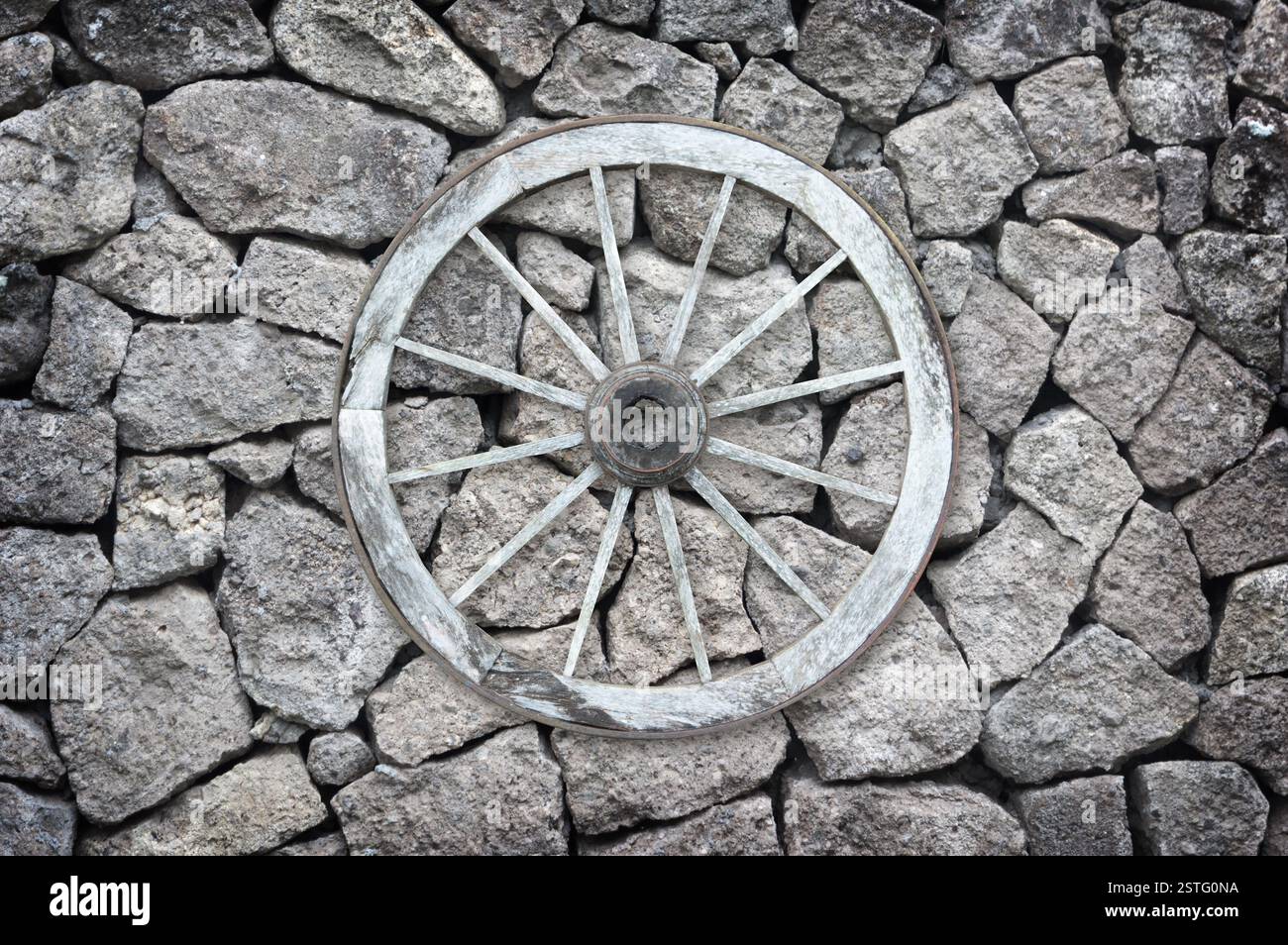 Wooden wagon wheel on a stone back ground Stock Photo - Alamy