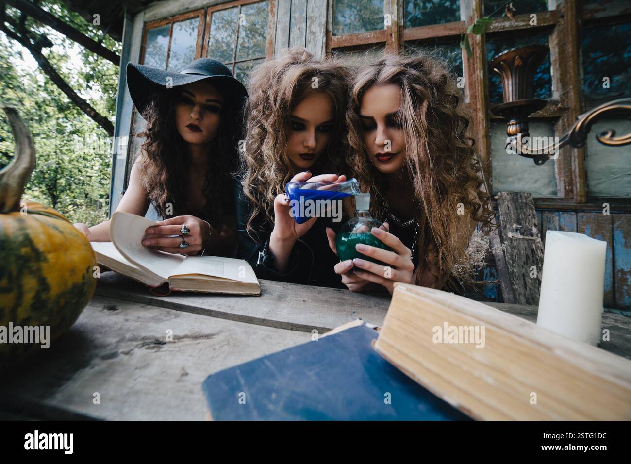 Three vintage witches perform magic ritual Stock Photo - Alamy