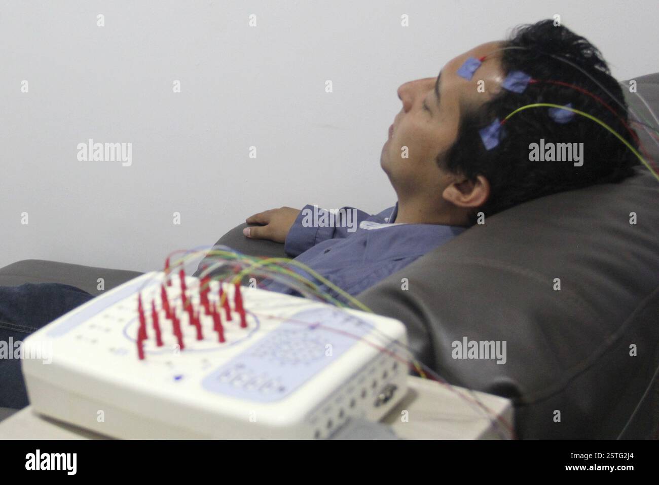 Electroencephalogram EEG in adult Latino man with wires in his head ...