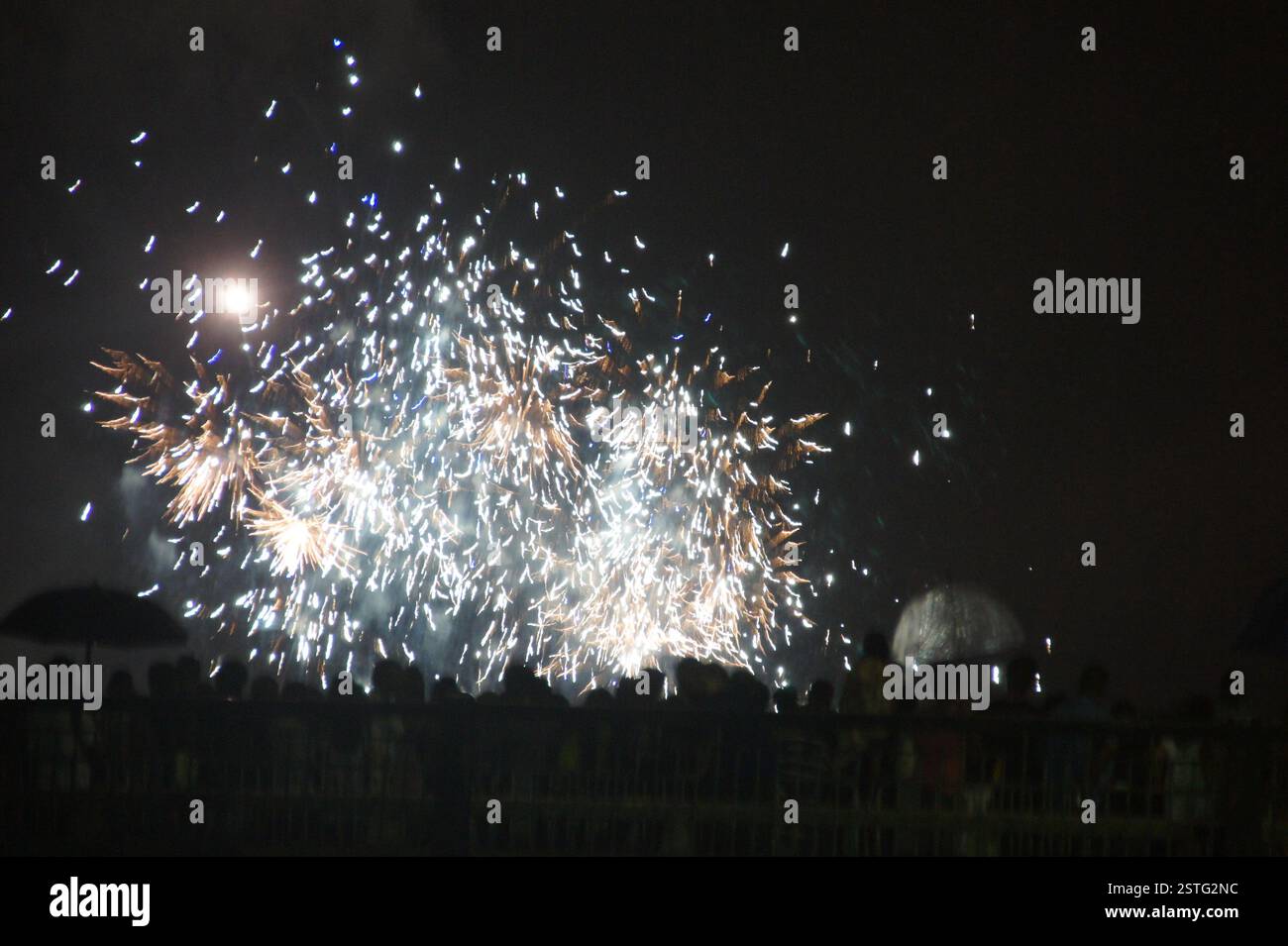 Boston fireworks display over a crowd at night. Bright bursts of light ...